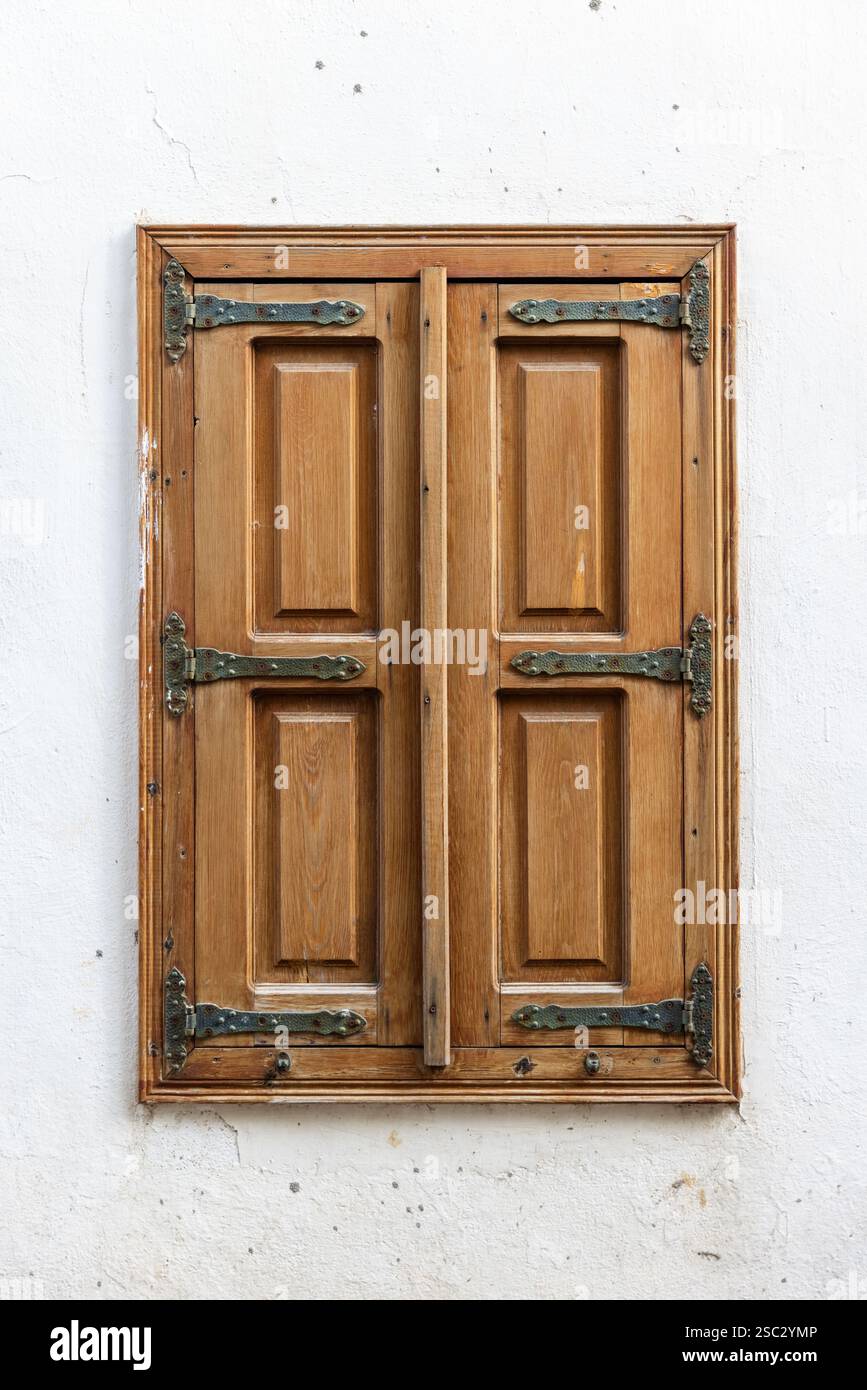 Old window with closed wooden shutters in white wall, background photo ...