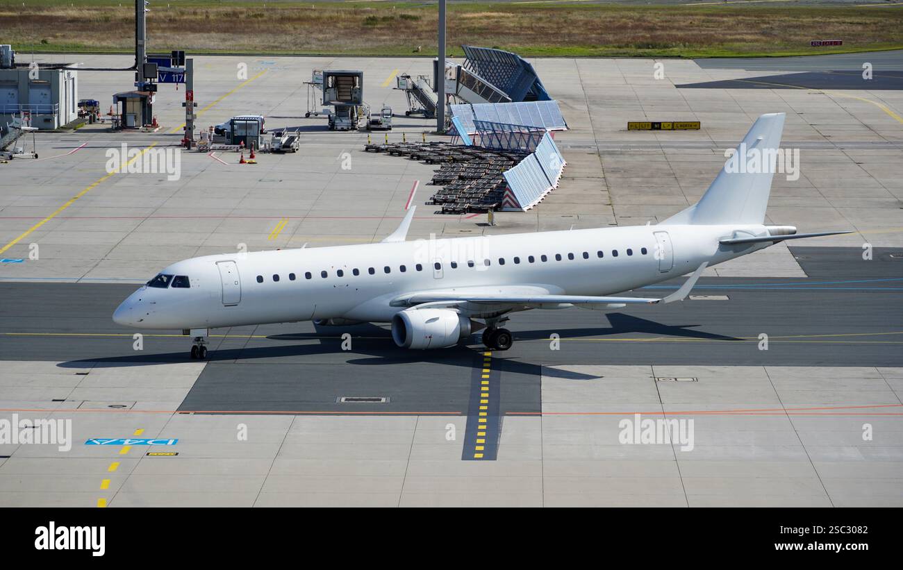 An all-white Embraer 190 aircraft taxis to the gate at Frankfurt ...