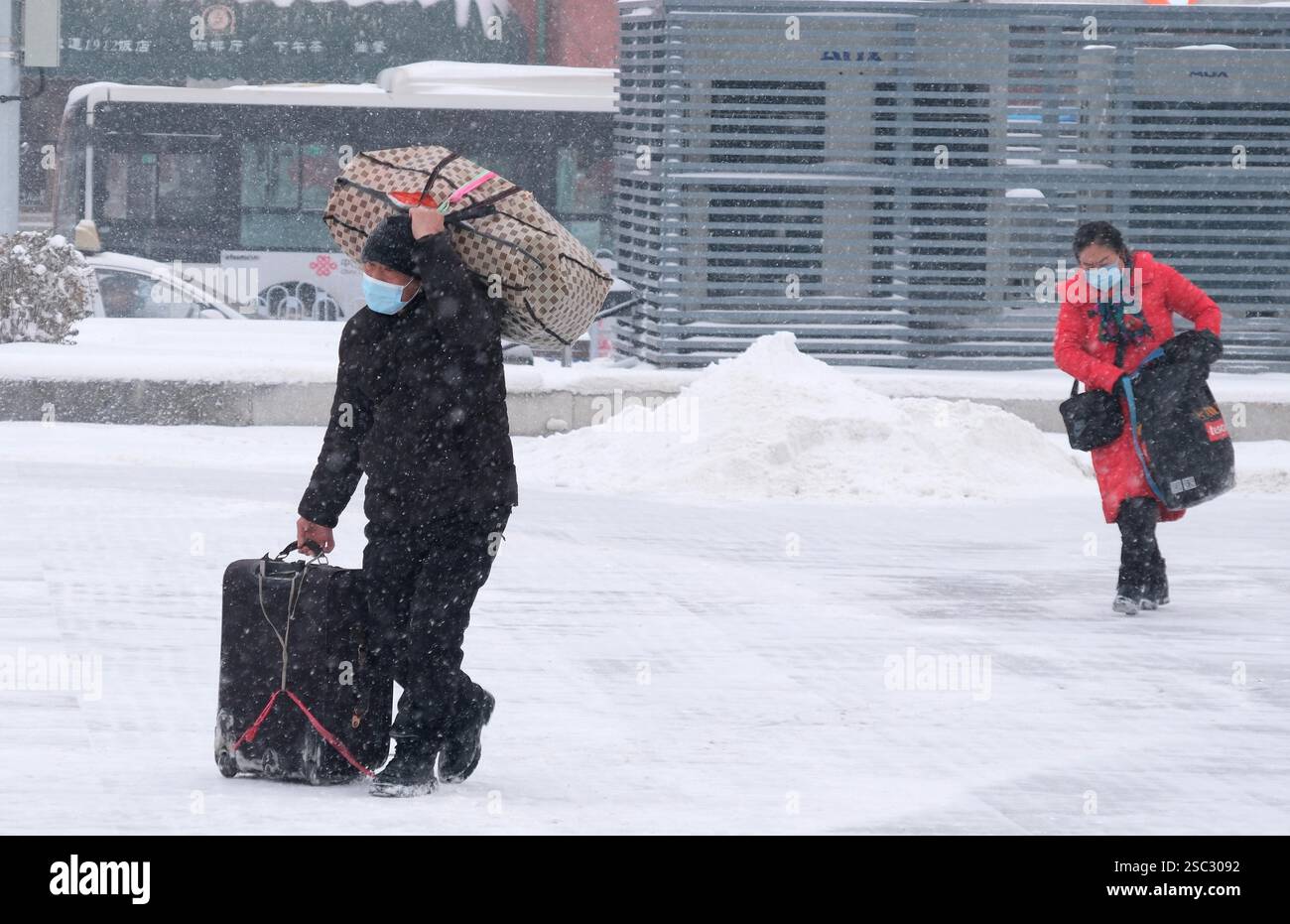 Passengers brave the snowfall to catch the train in Shenyang City ...