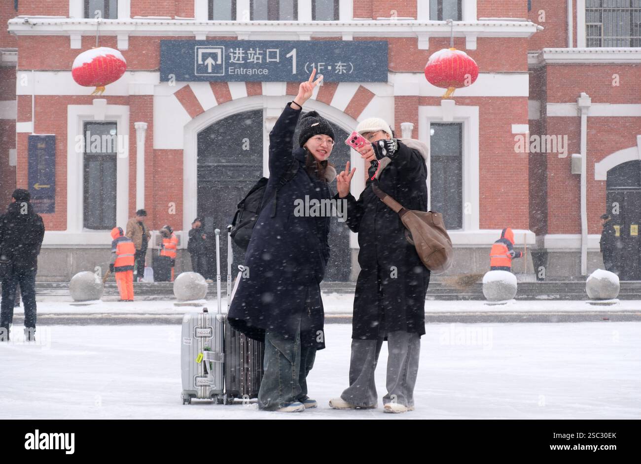 Passengers brave the snowfall to catch the train in Shenyang City ...