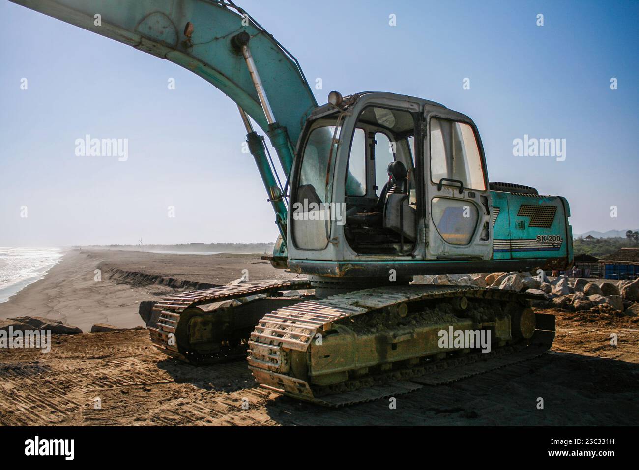 Excavator Without Driver Parked on Beach with Sunlight Glimmering Over ...