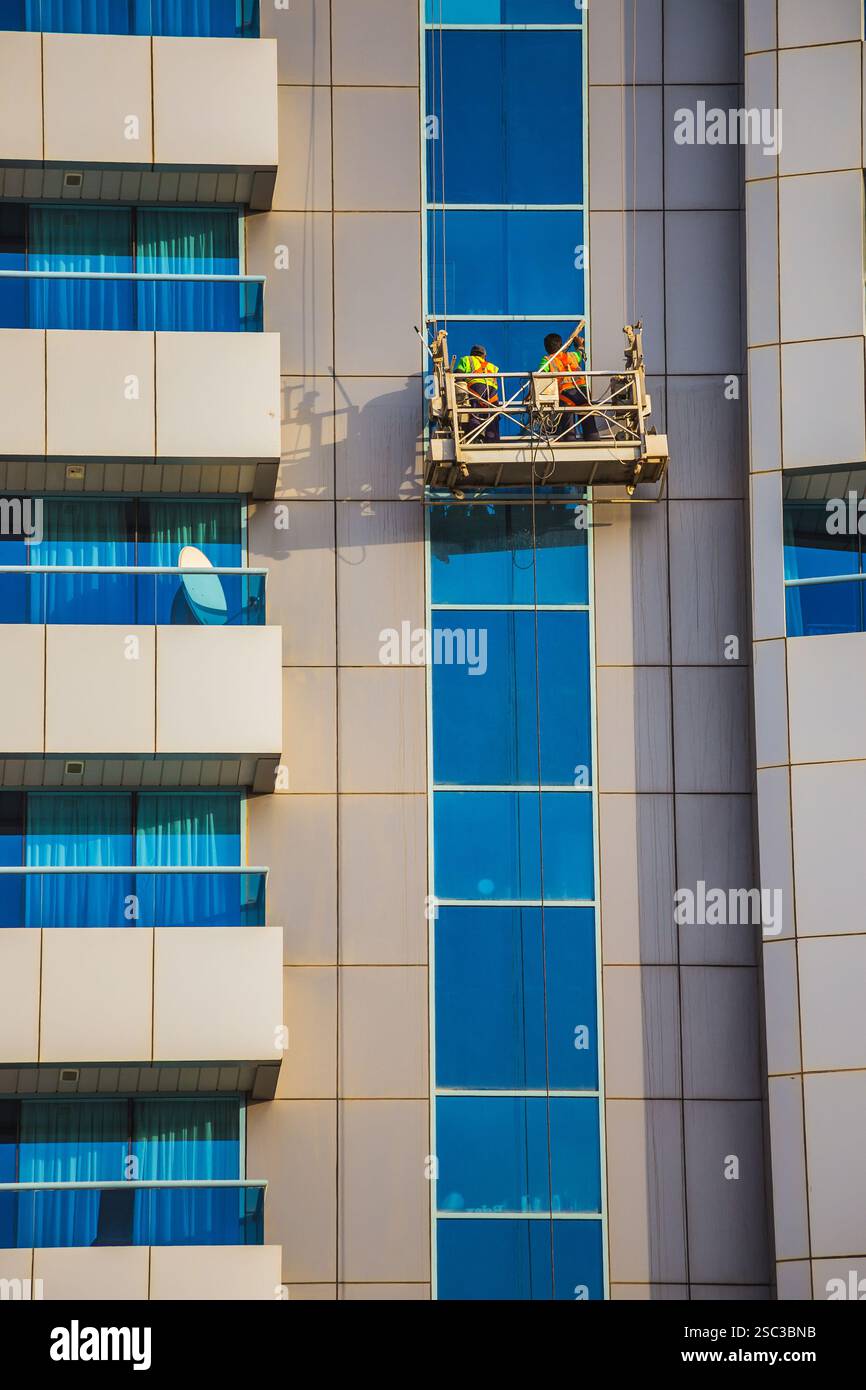 window cleaners in a gondola cleaning the windows of a corporate office ...