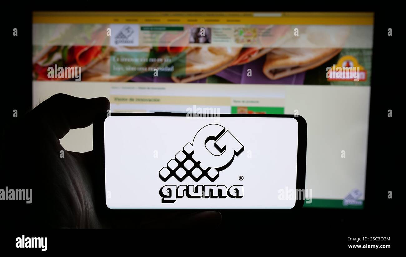 In this photo illustration, a person is holding a cellphone with the logo of Mexican food ...