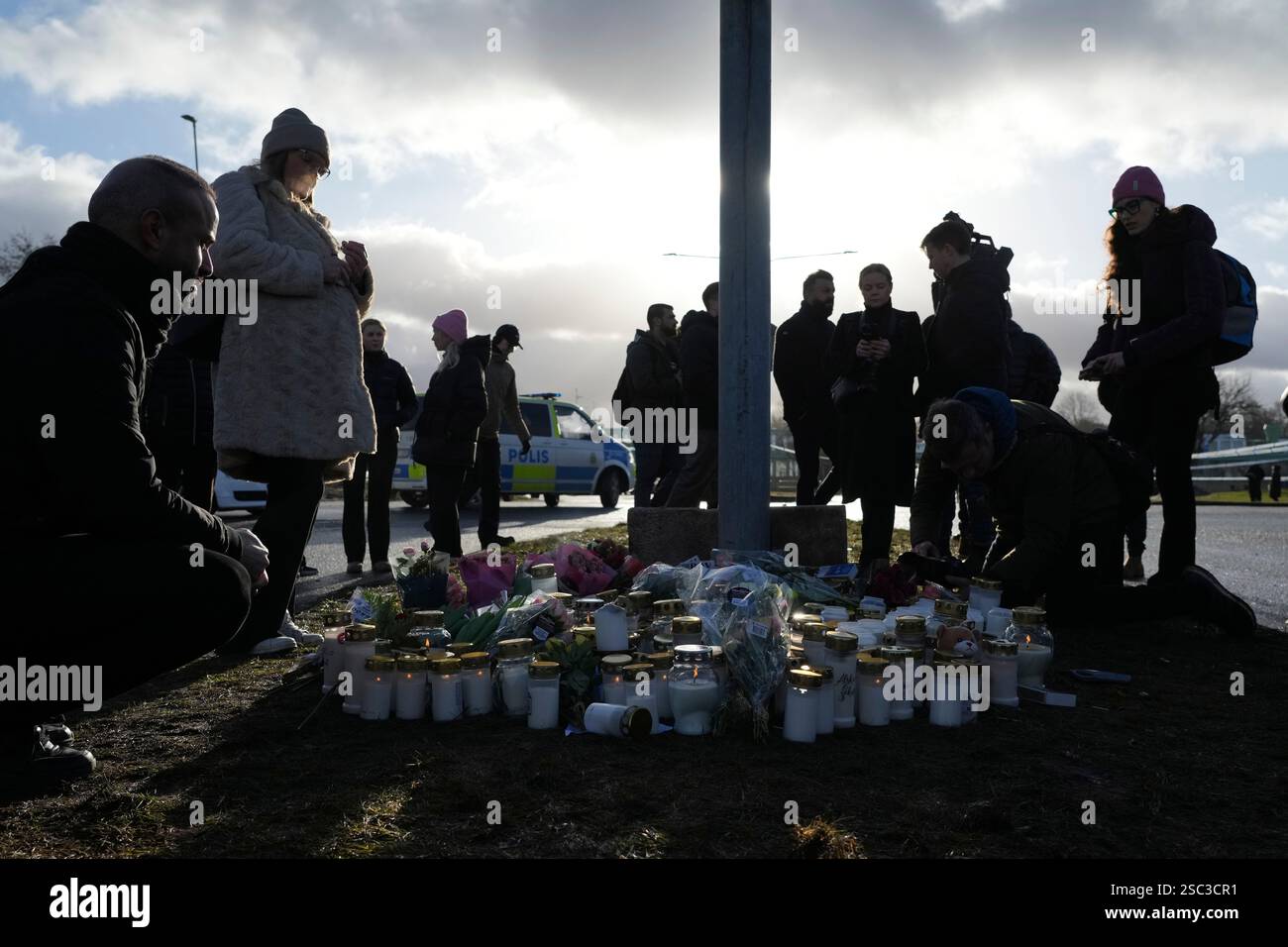 People gather at a makeshift memorial near the scene of a shooting on the outskirts of Orebro ...