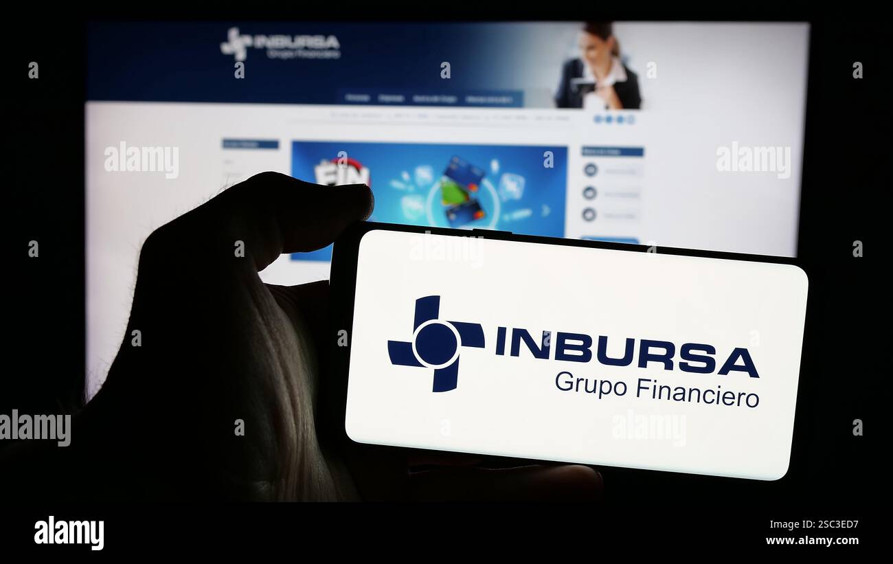 In this photo illustration, a person is holding a mobile phone with the ...