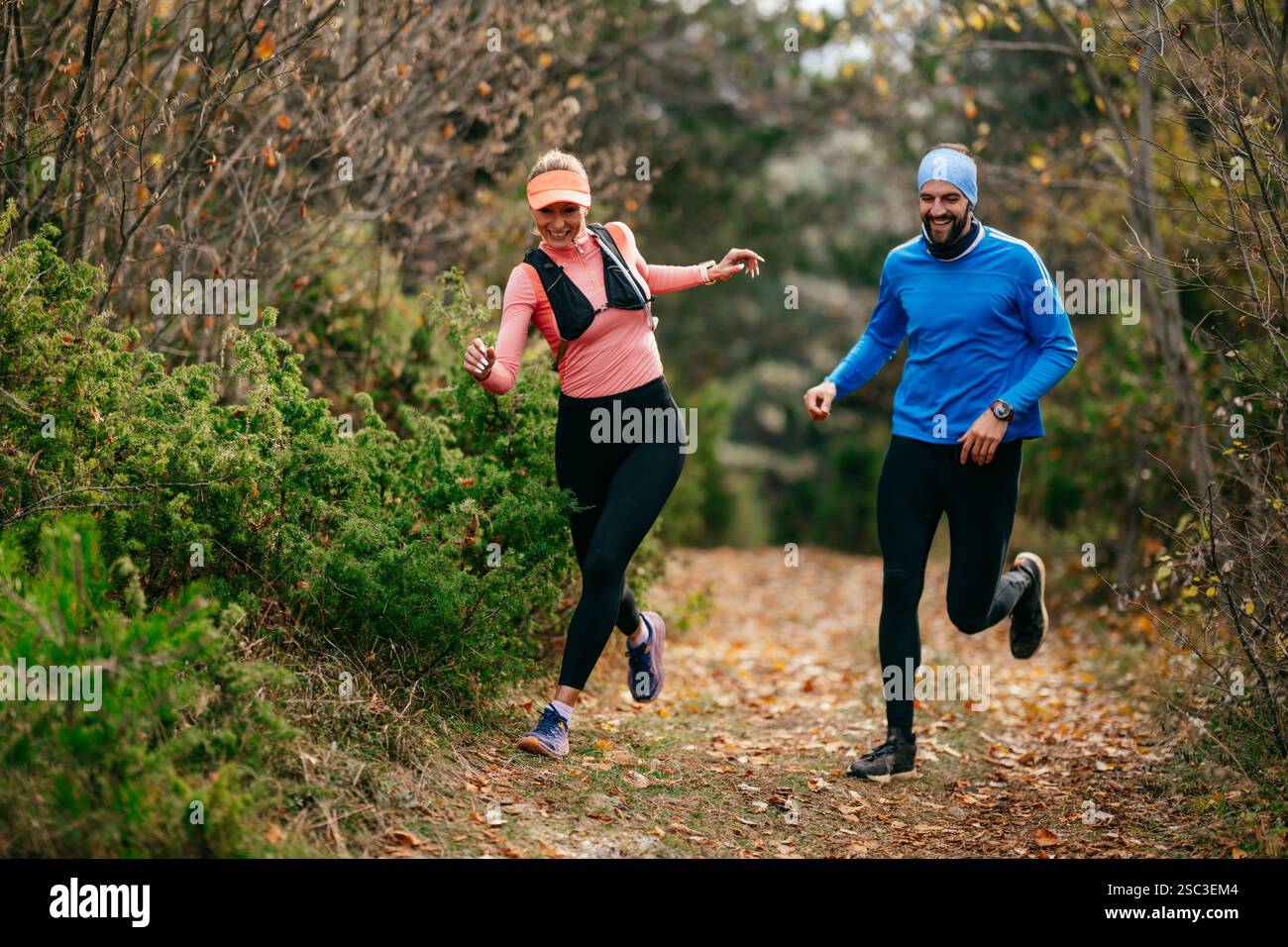 Happy Couple Running on a Forest Trail Stock Photo - Alamy