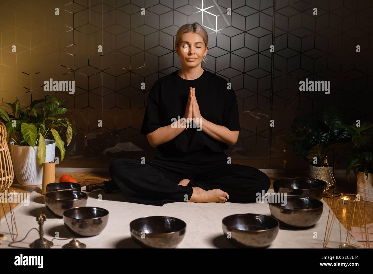 A person sits cross-legged on a mat in a peaceful indoor setting ...