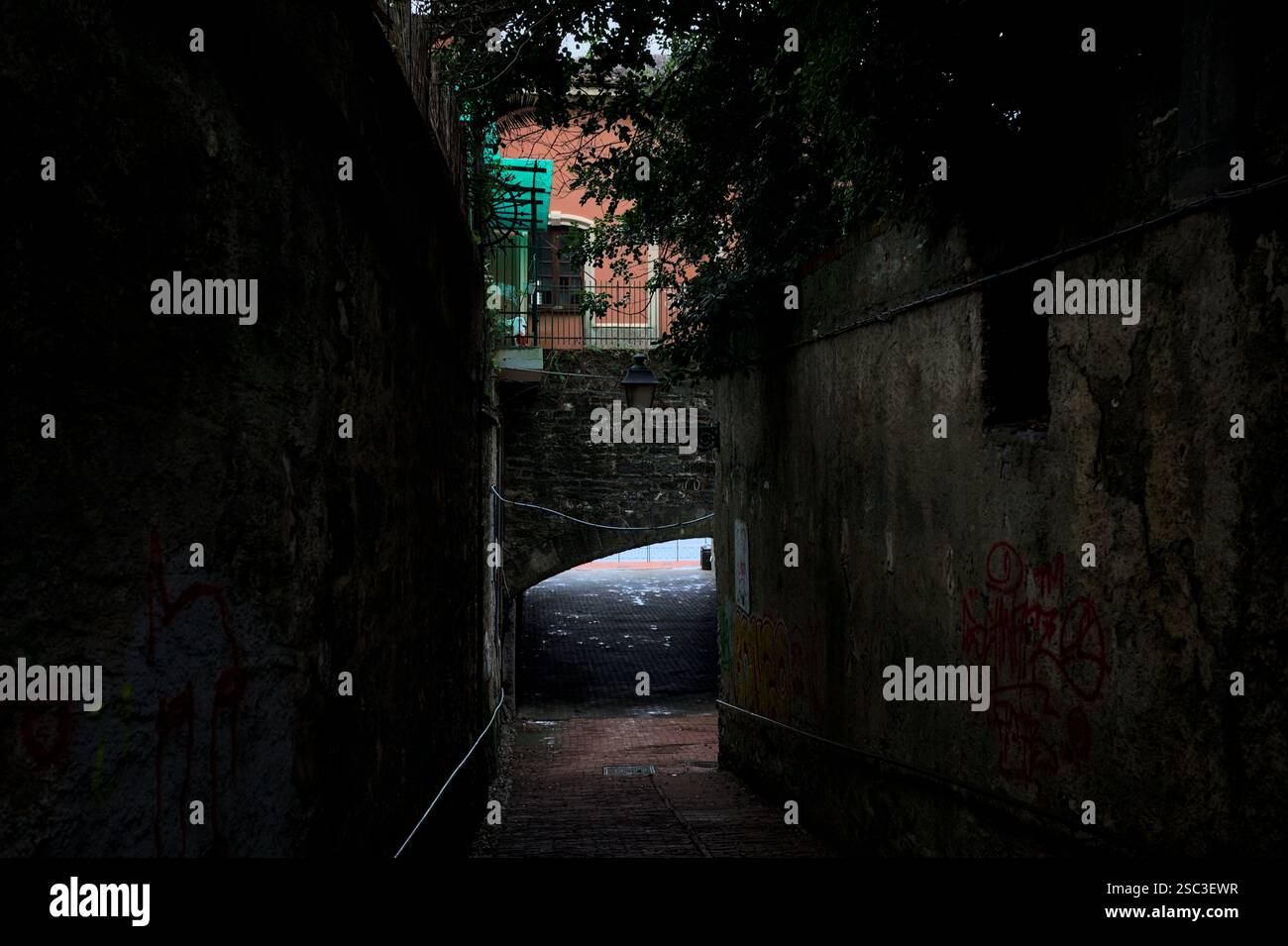 Staircase in an alley with trees passing under a building in an italian ...