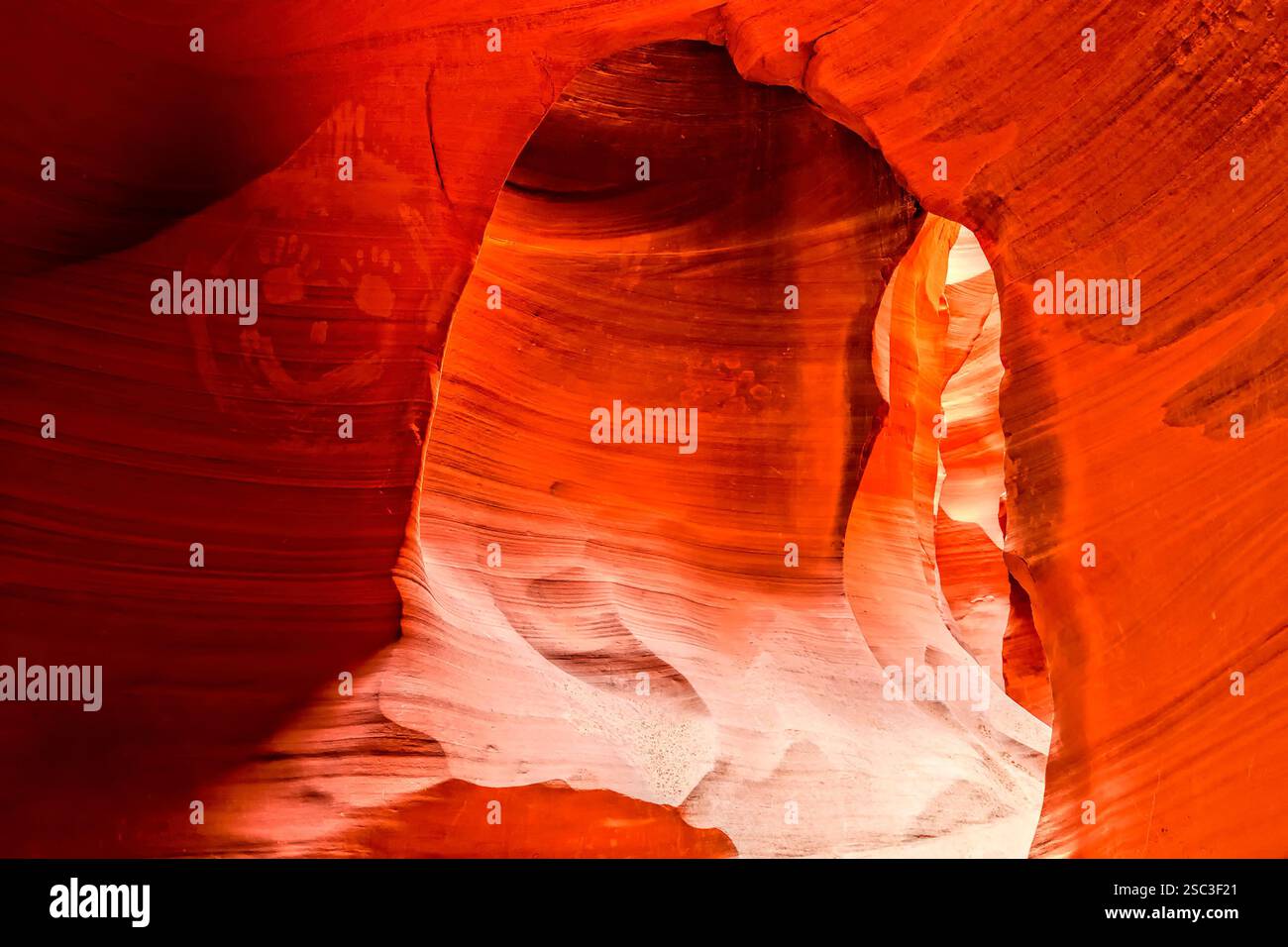 A red and white canyon with a smiling face on the wall. The canyon is ...