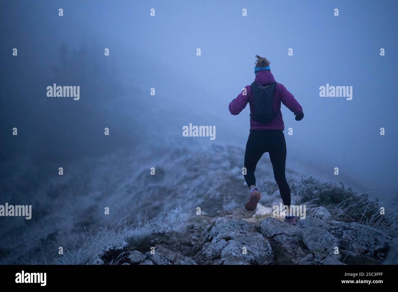 Determined Woman Trail Running at Night, Illuminated by a Headlamp in ...