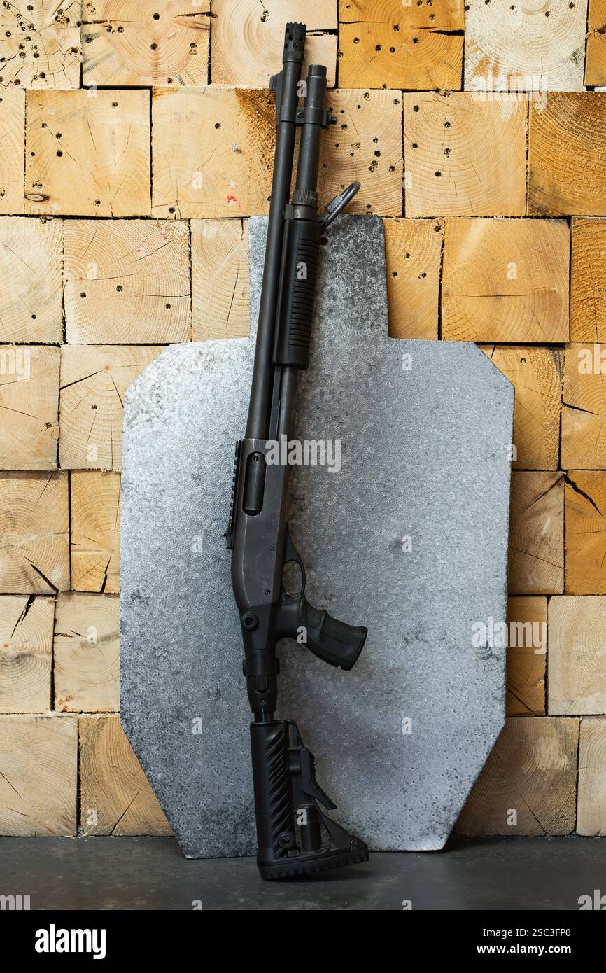 Firearms, tactical shotgun and metal target in a shooting range near a ...