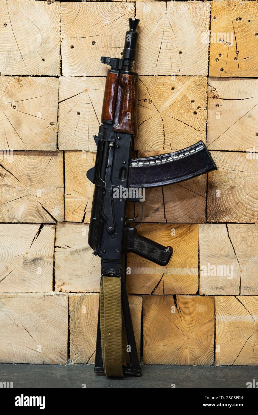 A compact Soviet AK series carbine at a shooting range near a wooden ...