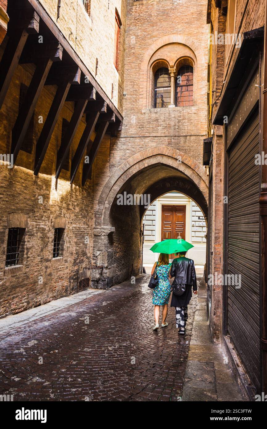 A lone passerby with an umbrella on a narrow street in the old city of ...