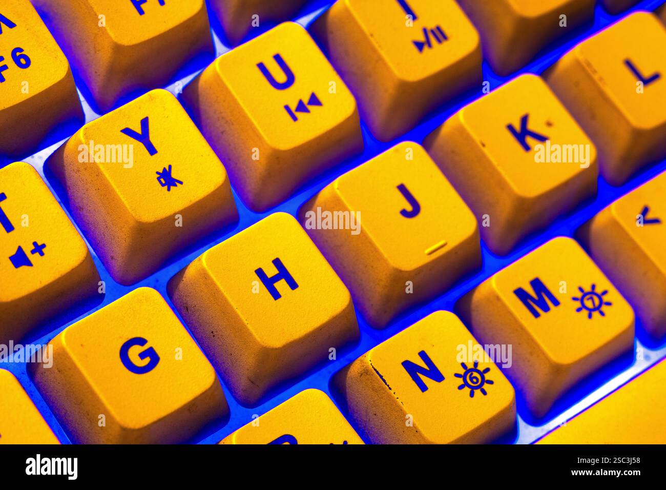 Bright yellow keyboard with blue light ambience Stock Photo - Alamy