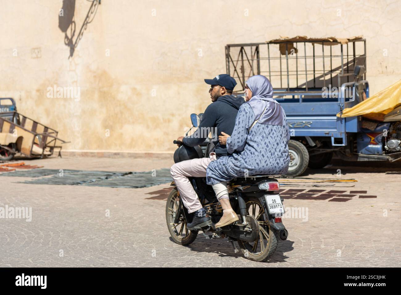 man and woman in traditional clothing without helmets riding a ...