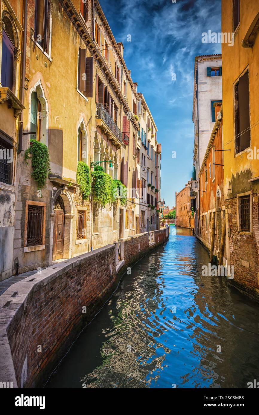 Narrow canal among old colorful brick houses in Venice, Italy Stock ...