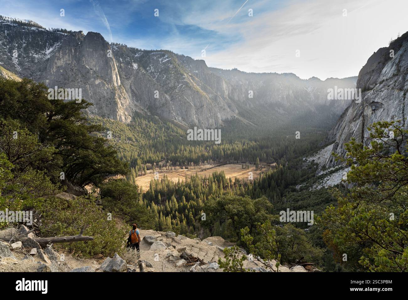 Hiker descends trail overlooking Yosemite Valley, CA. Iconic granite ...