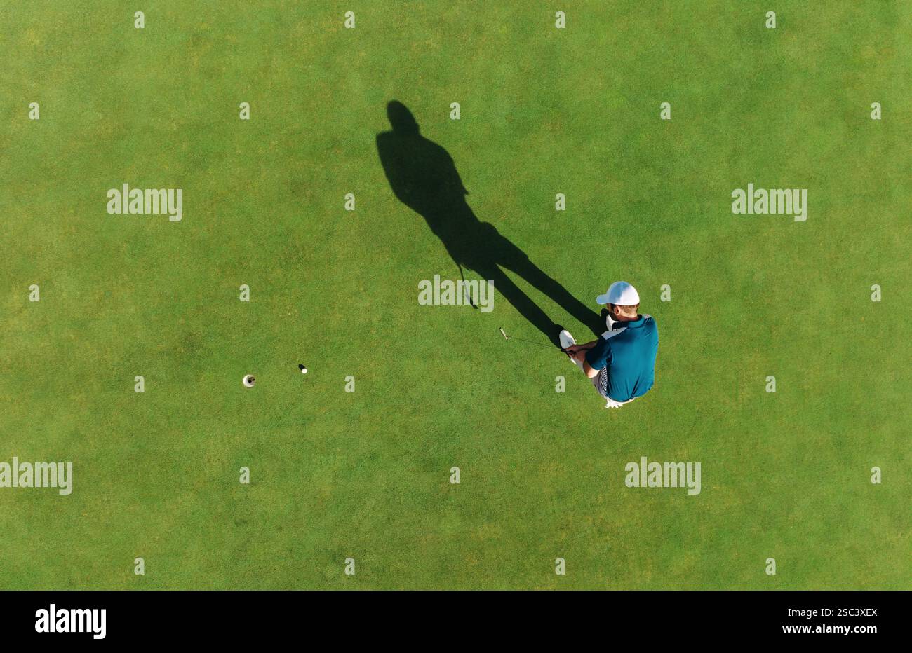 Aerial view of a man taking a golf action shot and putting on a green ...