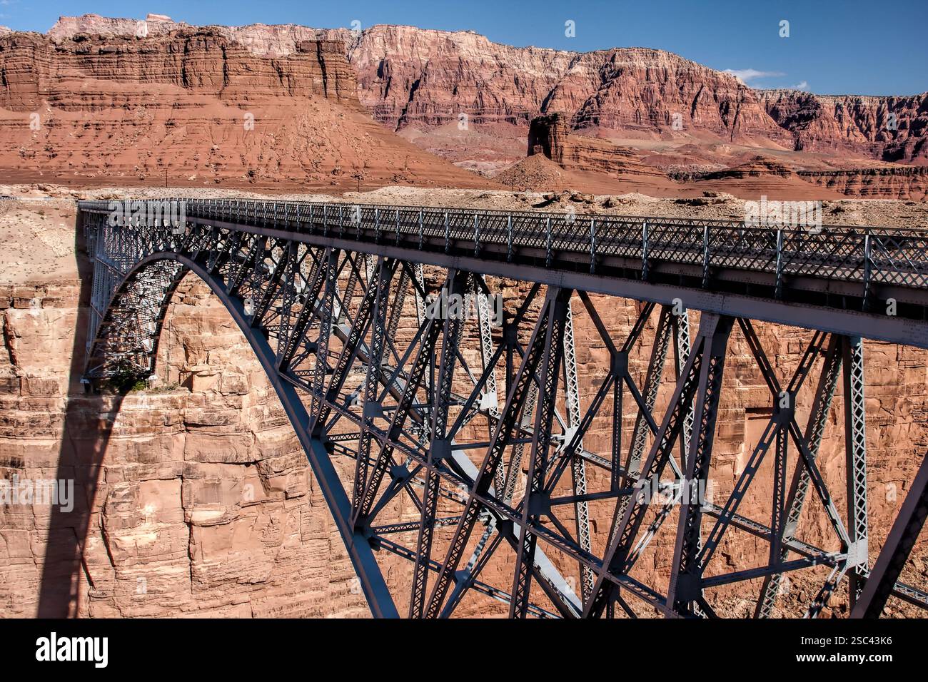 A bridge over a canyon with a view of the mountains. The bridge is made ...