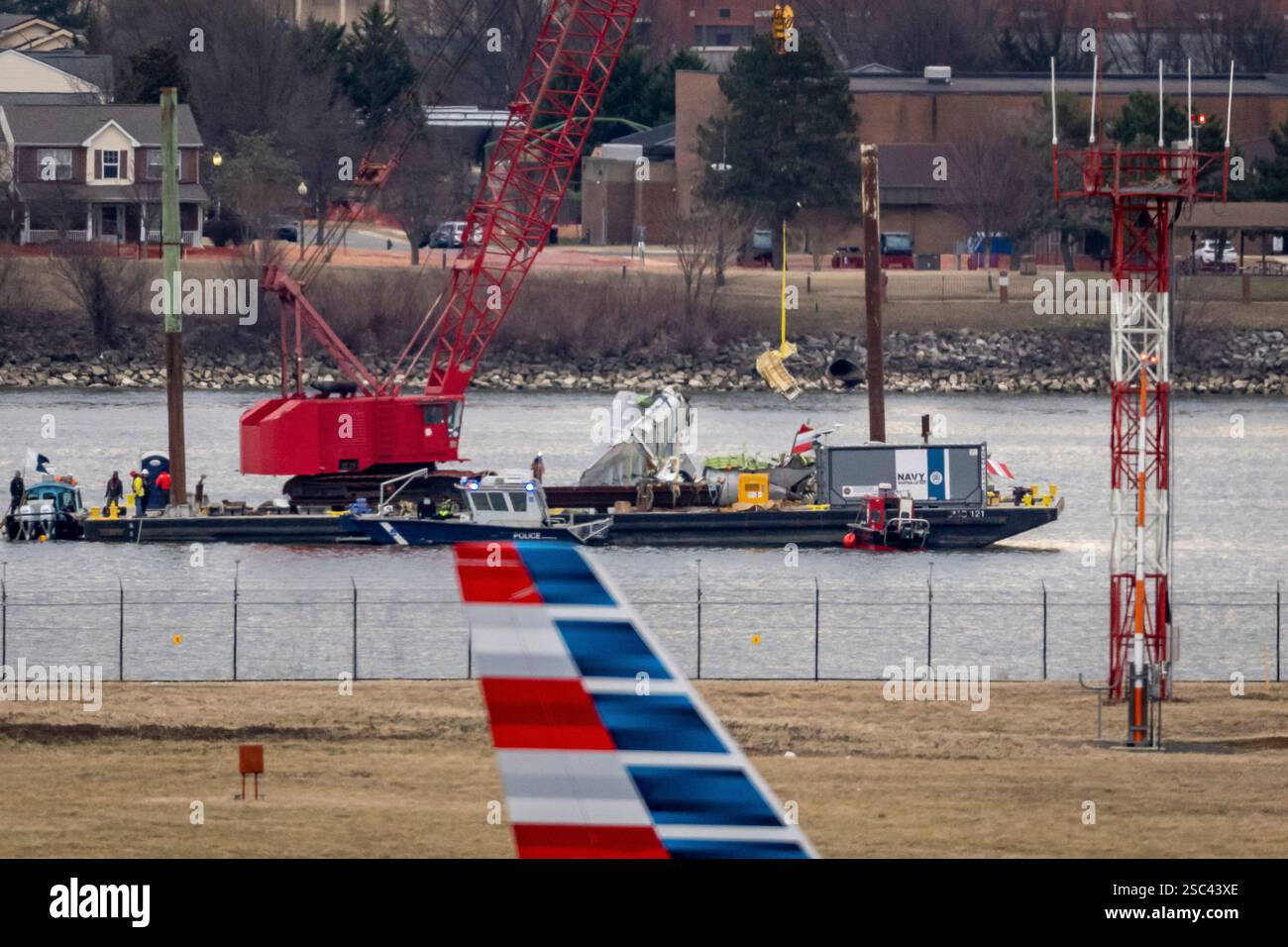 Salvage crews lift a piece of wreckage from the water, near the wreckage site in the Potomac ...