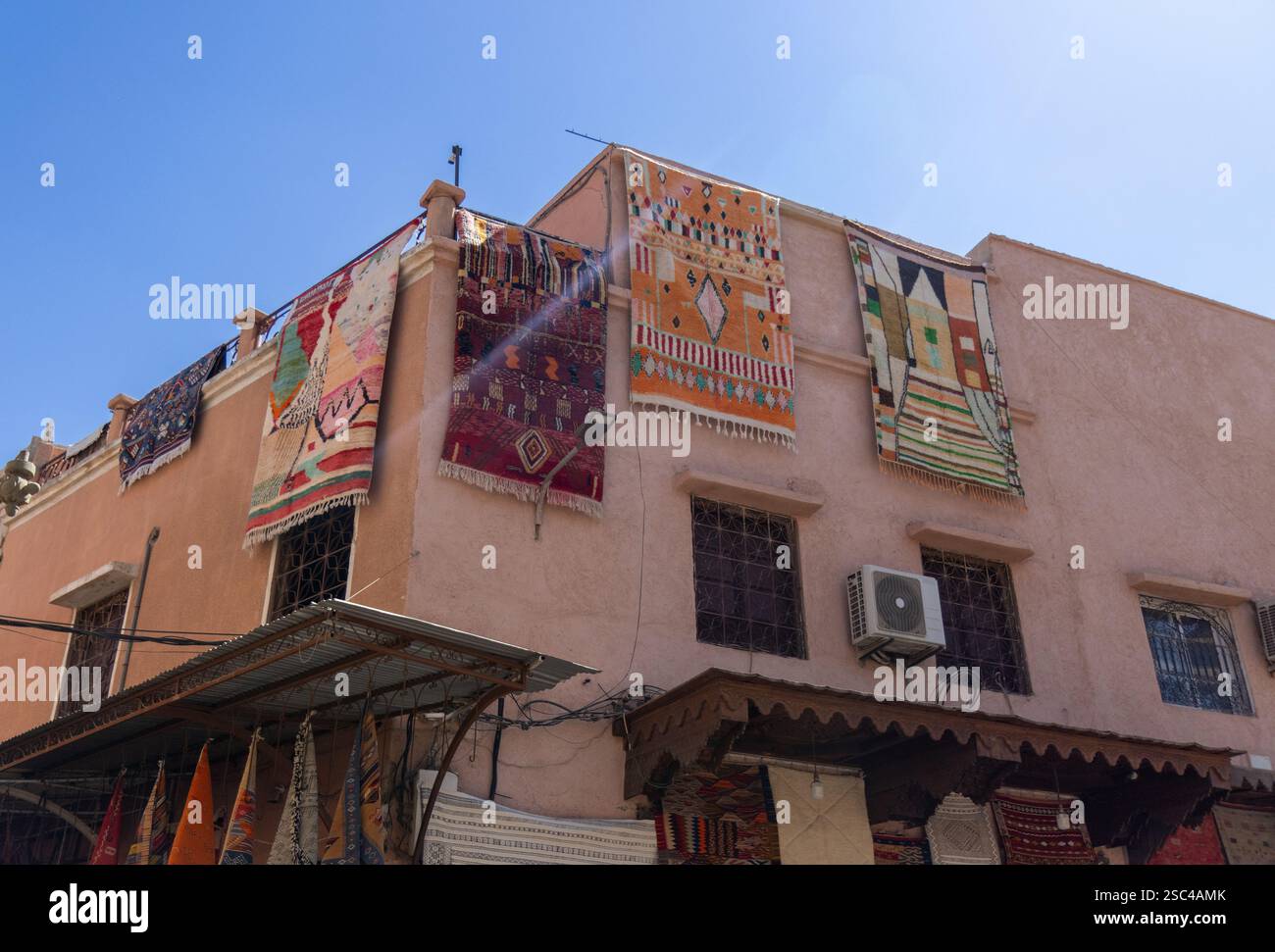 Marrakech medina building with traditional artisan carpets hanging from ...
