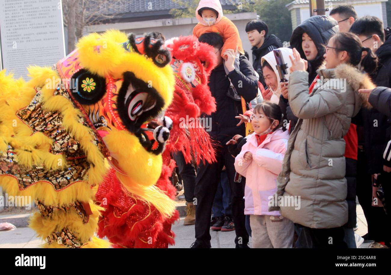 (250205) -- BEIJING, Feb. 5, 2025 (Xinhua) -- Tourists watch lion dance ...