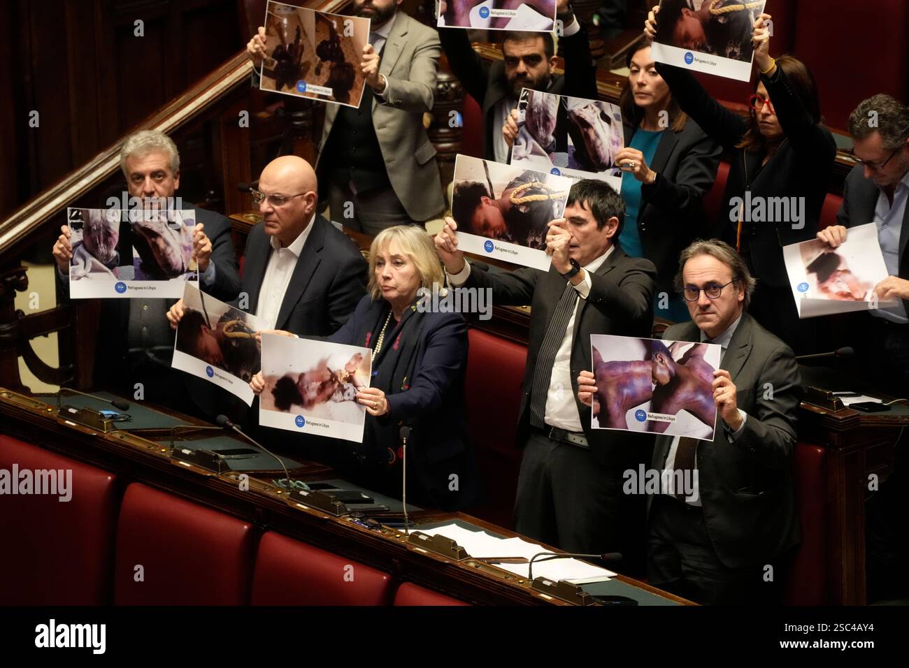 Opposition members of parliament hold posters showing tortured bodies ...