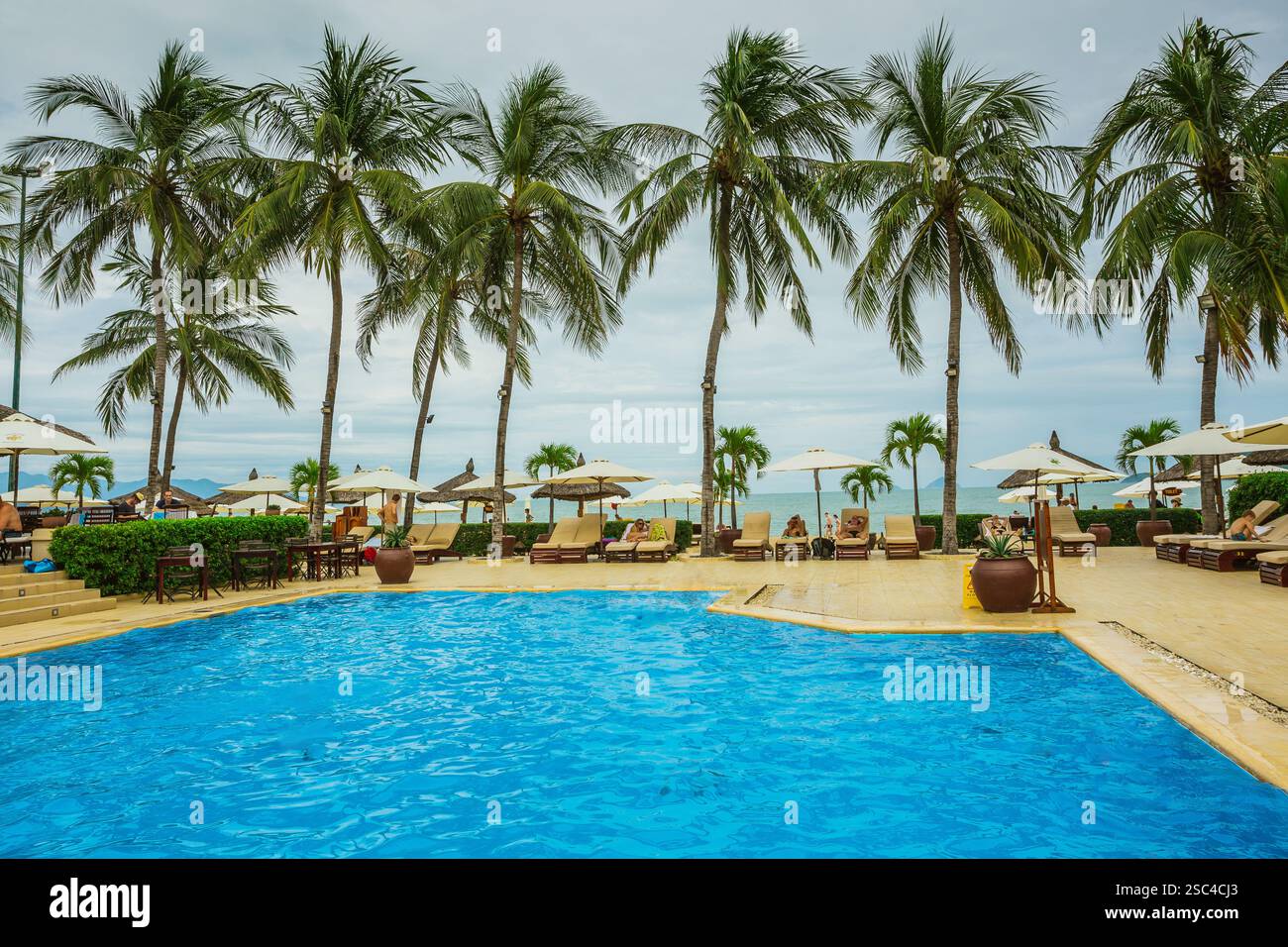 Nha Trang NOV 28, 2021. Tropical Resort Pool with Lounge Chairs, Palm Trees, and Ocean View. Nha ...