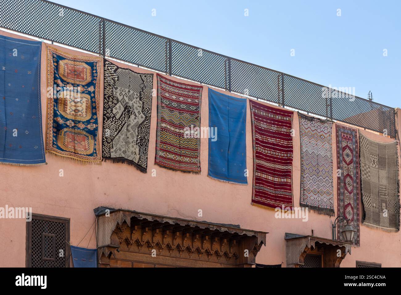 Marrakech medina building with traditional artisan carpets hanging from ...