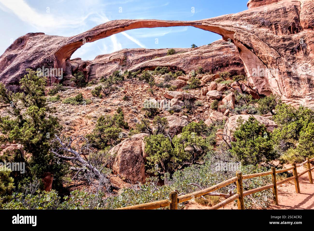 A bridge over a canyon with a fence on the side. The bridge is arched ...