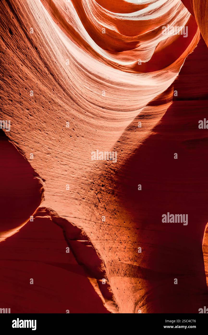 A red rock formation with a brownish color. The rock is curved and has ...