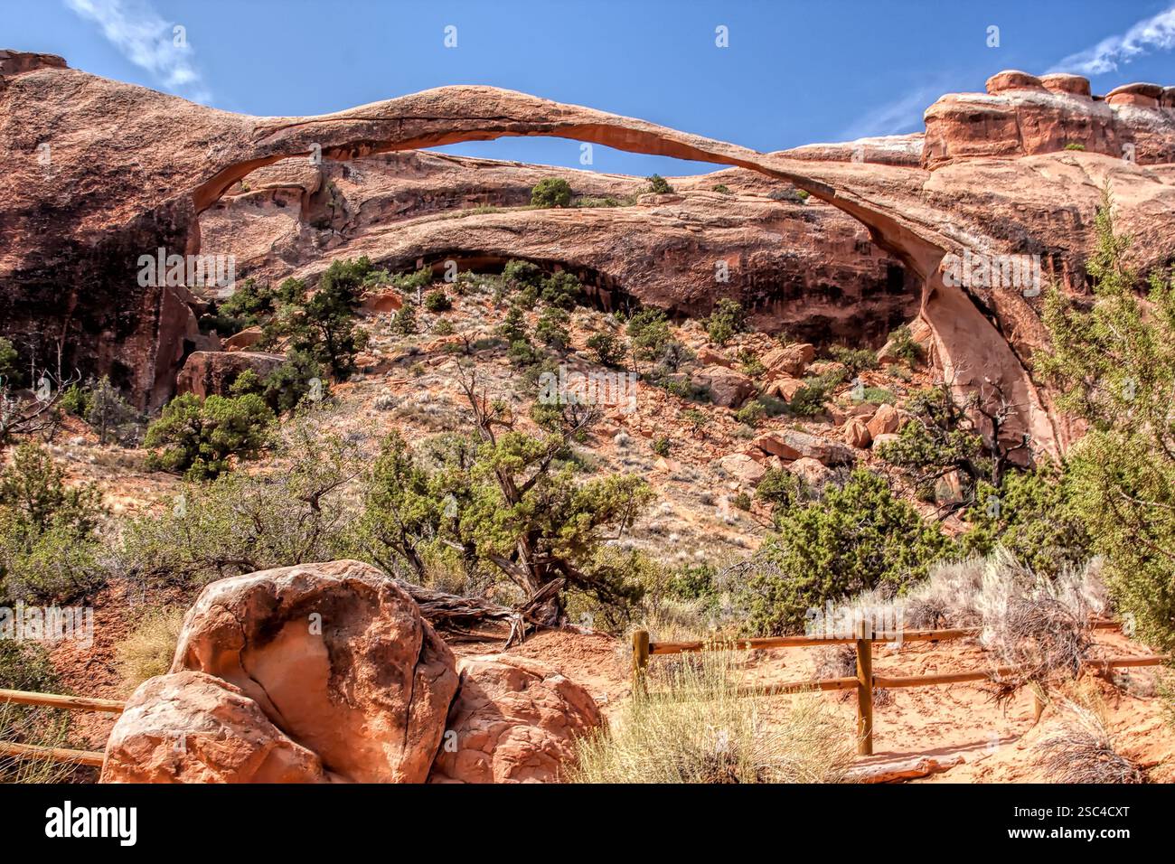 A large archway is in the middle of a rocky hill. The archway is ...