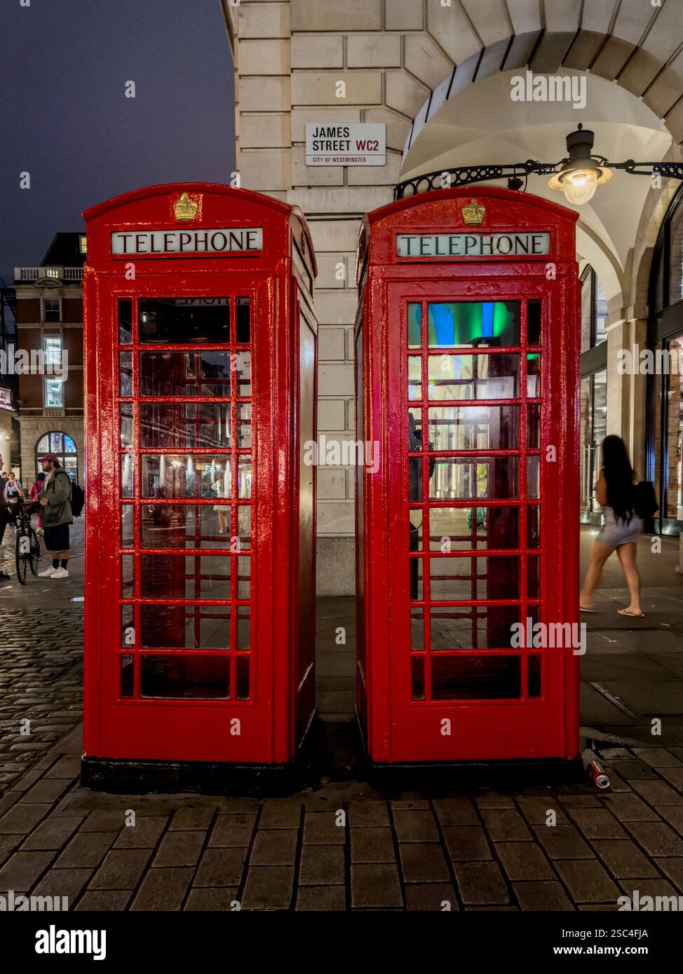 Two icconic red telephone booths at night in Covent Garden, London ...