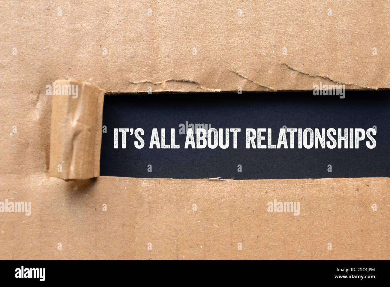 It’s all about relationships message written on ripped torn cardboard paper on black background ...