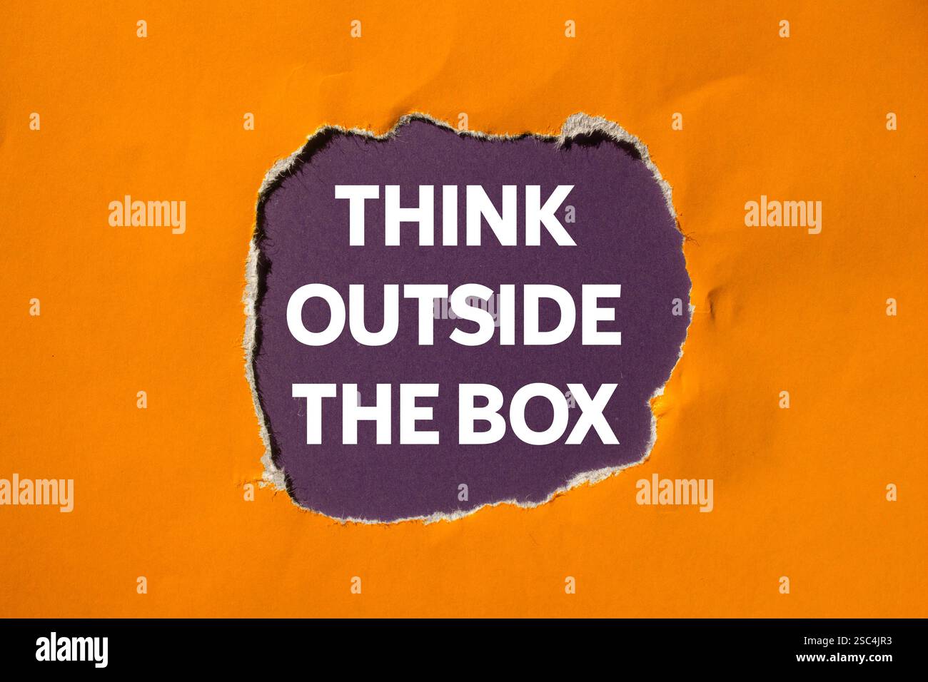 Think outside the box message written on ripped torn orange paper on ...