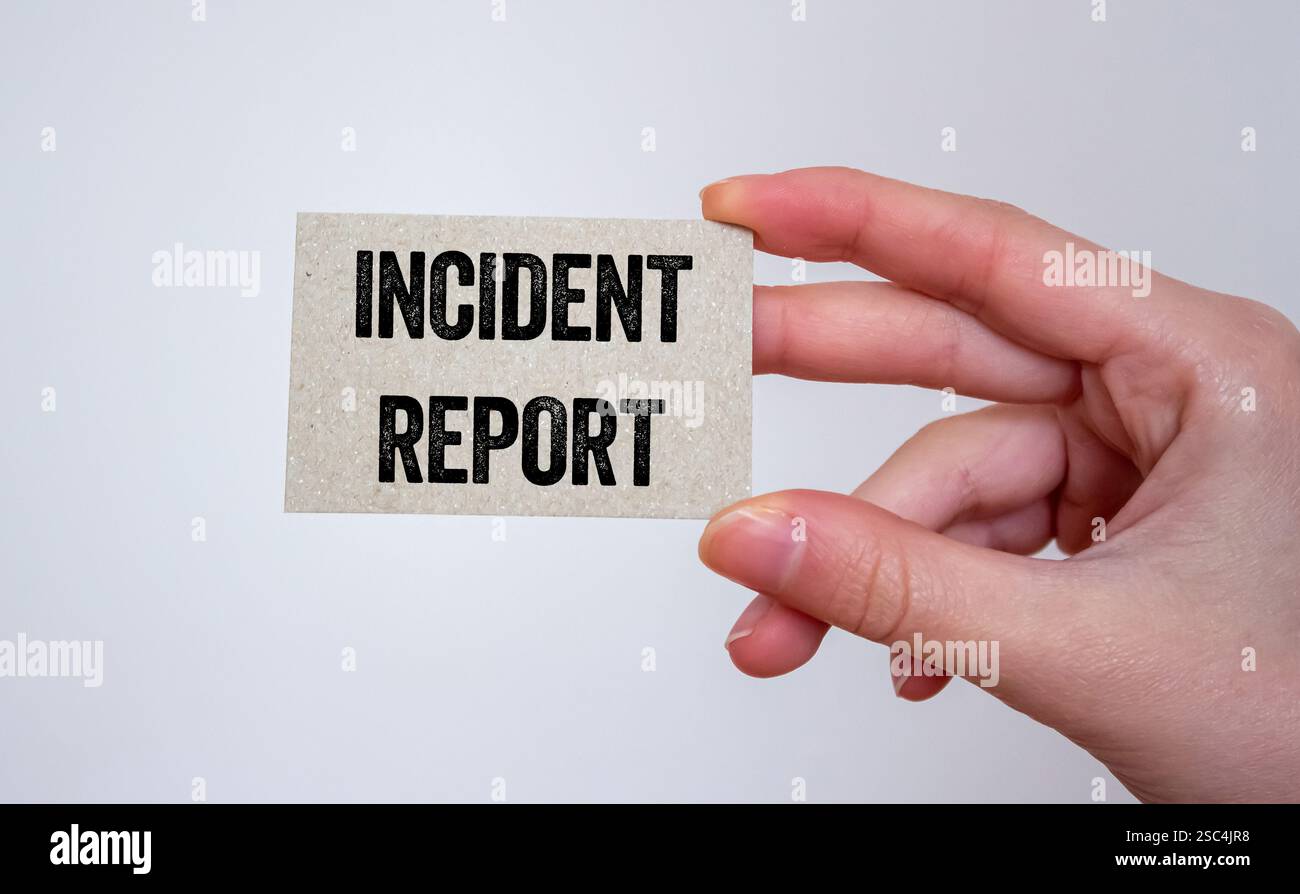 Incident report message written on a card in hand. Conceptual incident ...