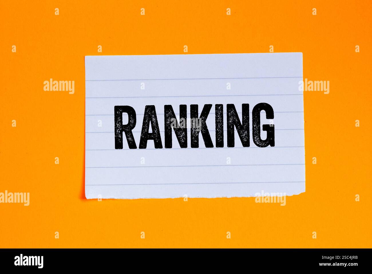 Ranking message written on ripped torn white paper piece on orange ...