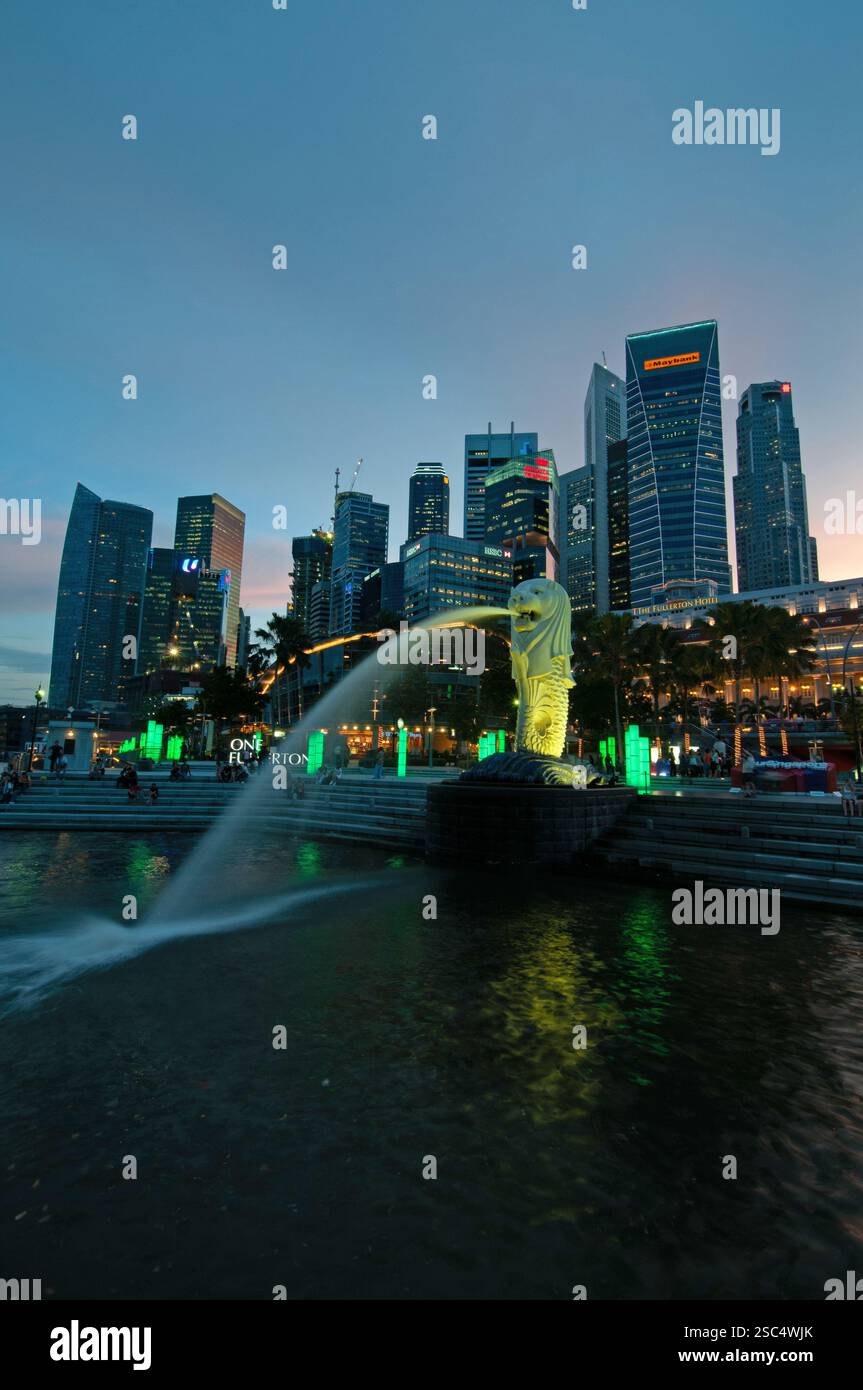 Dusk over the financial district and the symbol of Singapore, the ...