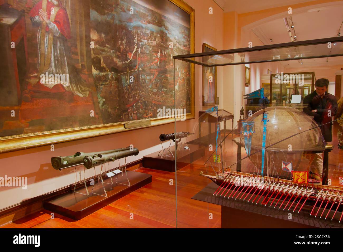 Room with model ships in glass display cases paintings cannons and a ...