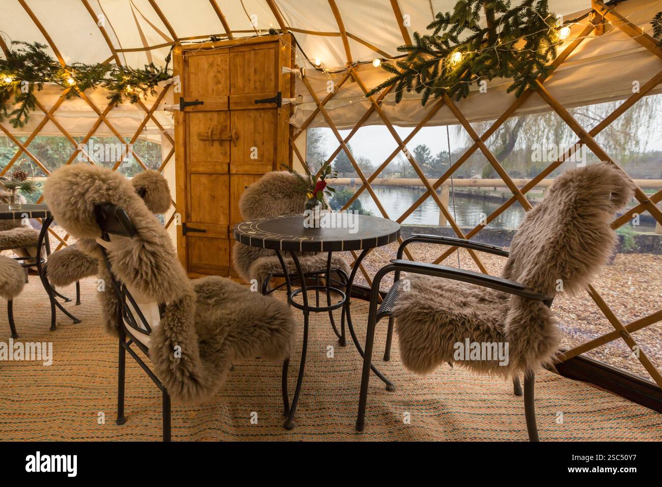 A yurt cafe in the style of a hygge ski lodge, warmed by a wood fired ...