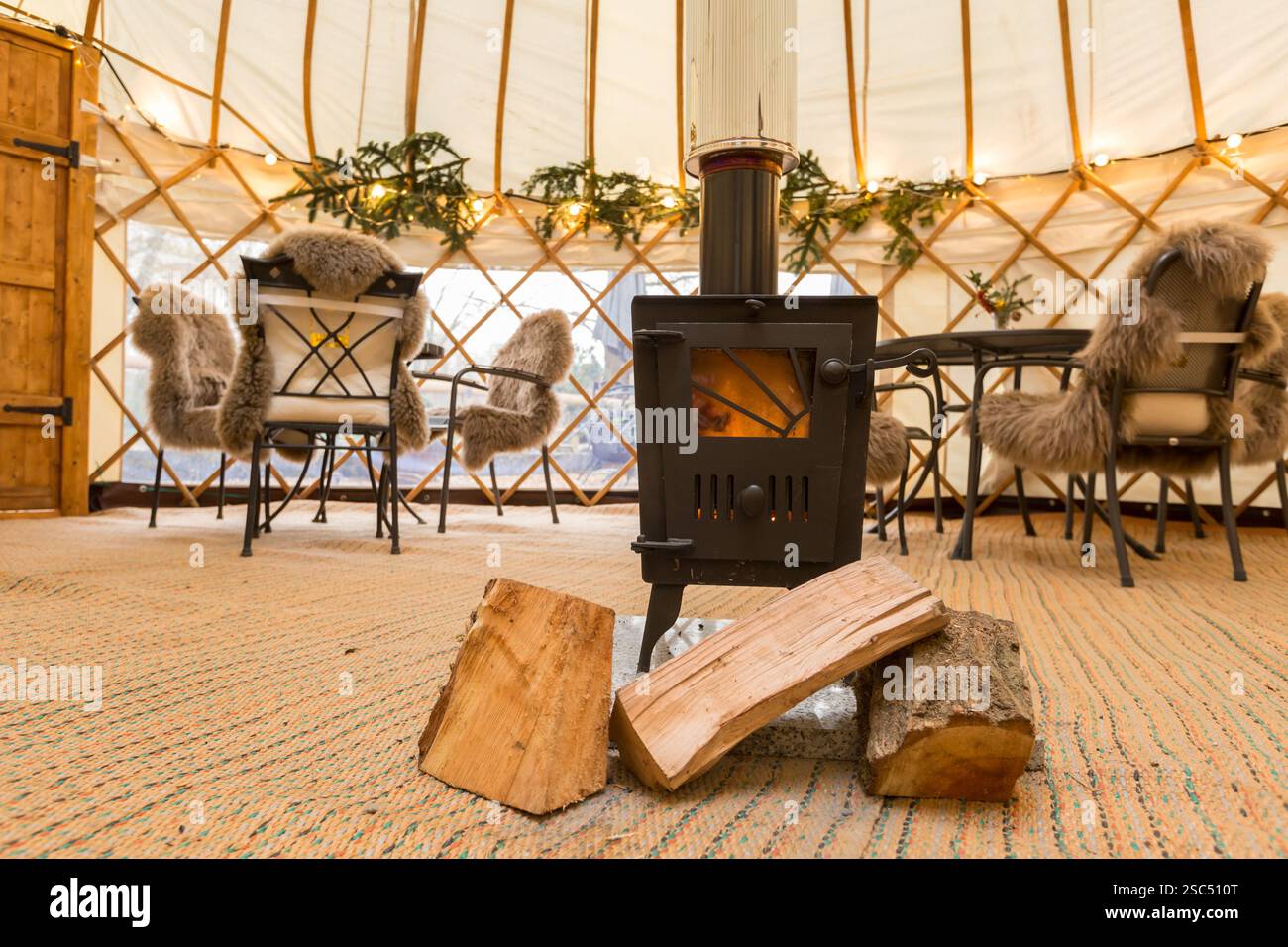 A yurt cafe in the style of a hygge ski lodge, warmed by a wood fired ...