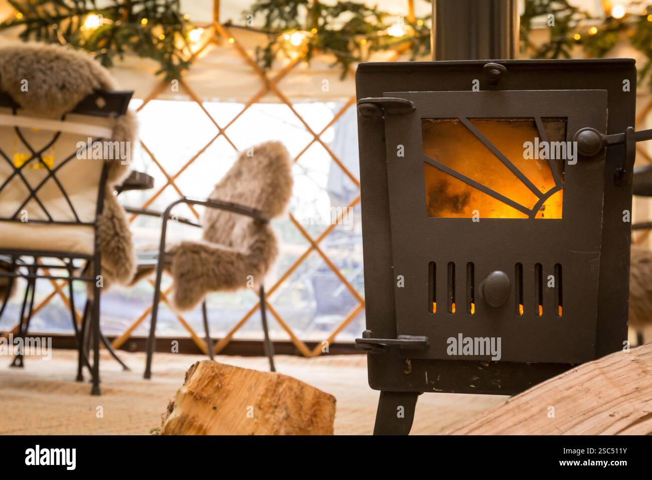 A yurt cafe in the style of a hygge ski lodge, warmed by a wood fired ...