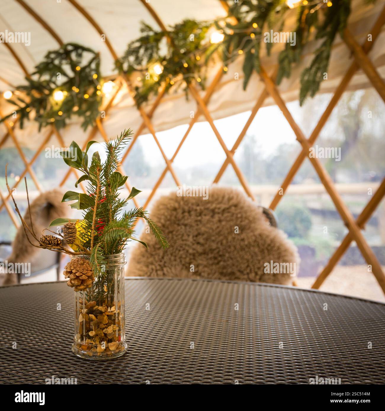 A yurt cafe in the style of a hygge ski lodge, warmed by a wood fired ...