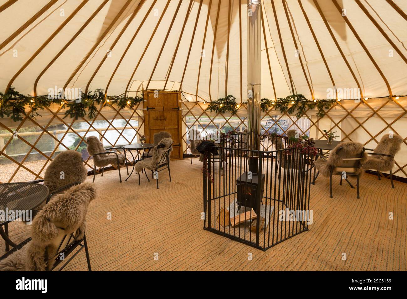 A yurt cafe in the style of a hygge ski lodge, warmed by a wood fired ...