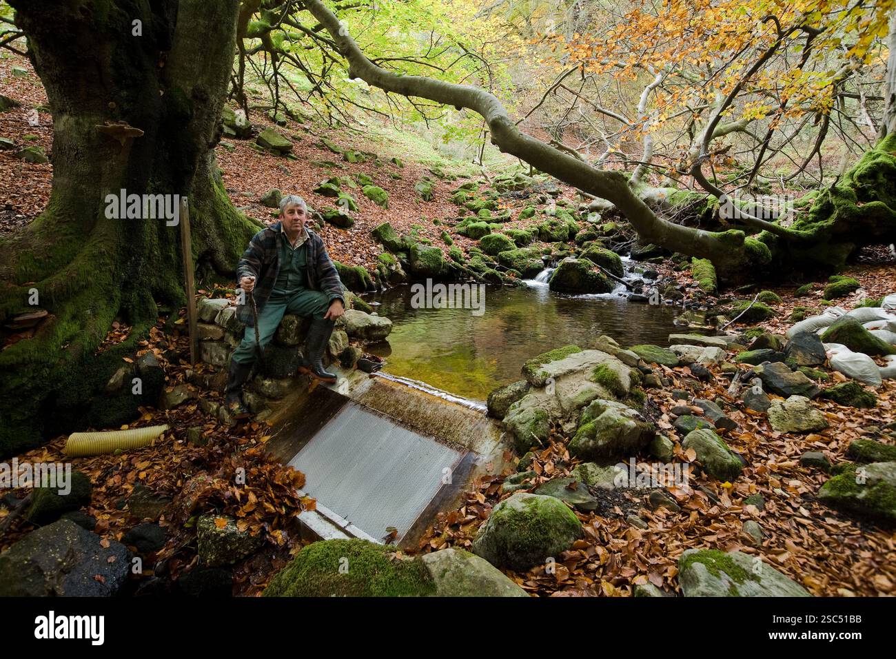 Alan Williams sists by the water intake to his hydro scheme on his farm ...
