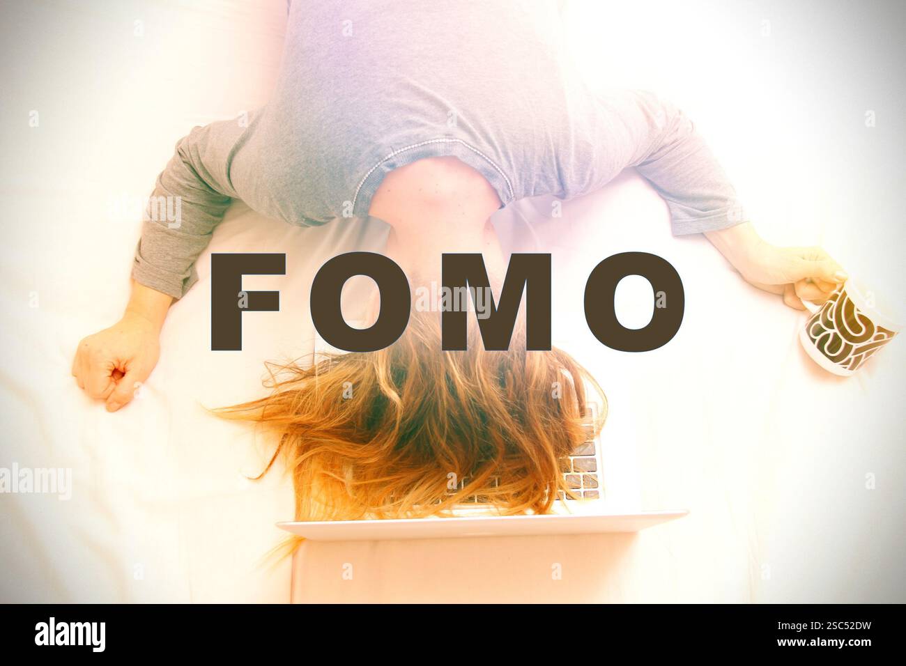 Woman crashing on a computer screen . Word "Fomo" concept of "Fear of ...