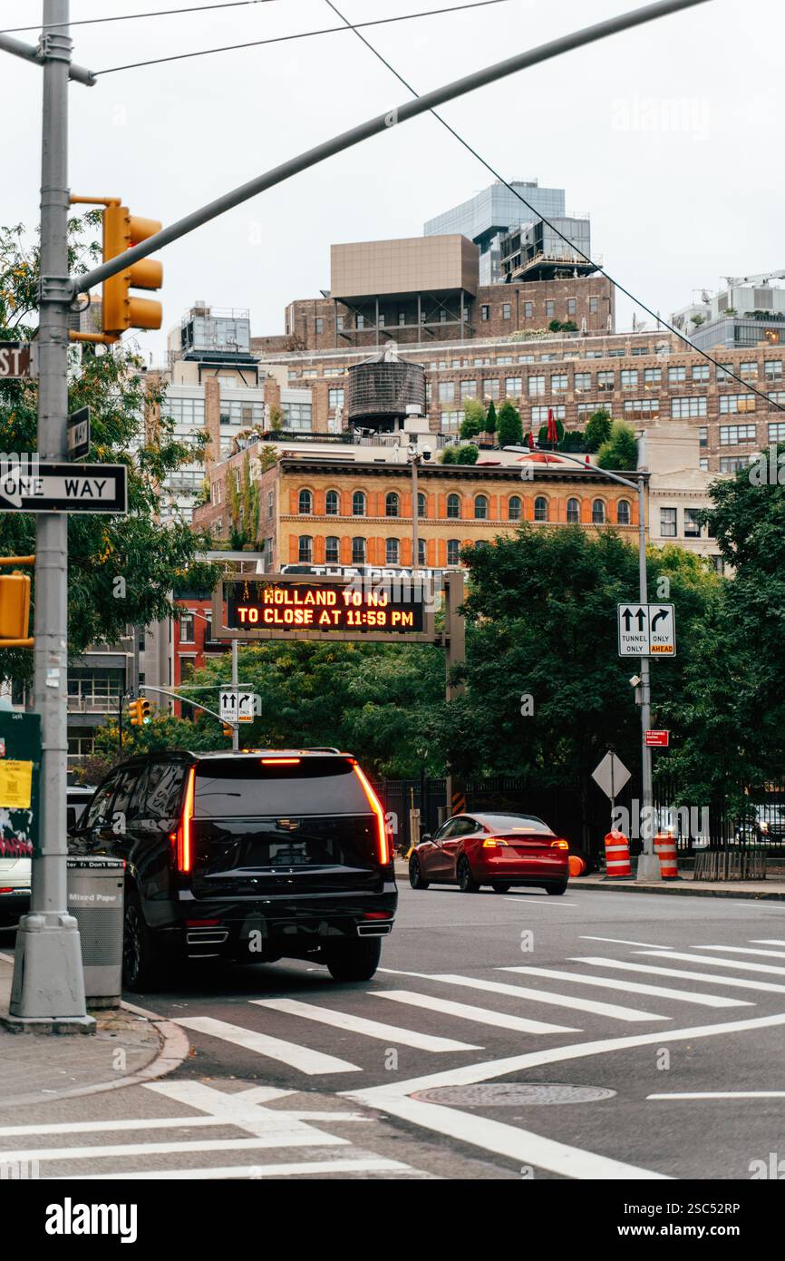 Vehicles approach a busy intersection with a traffic message board ...