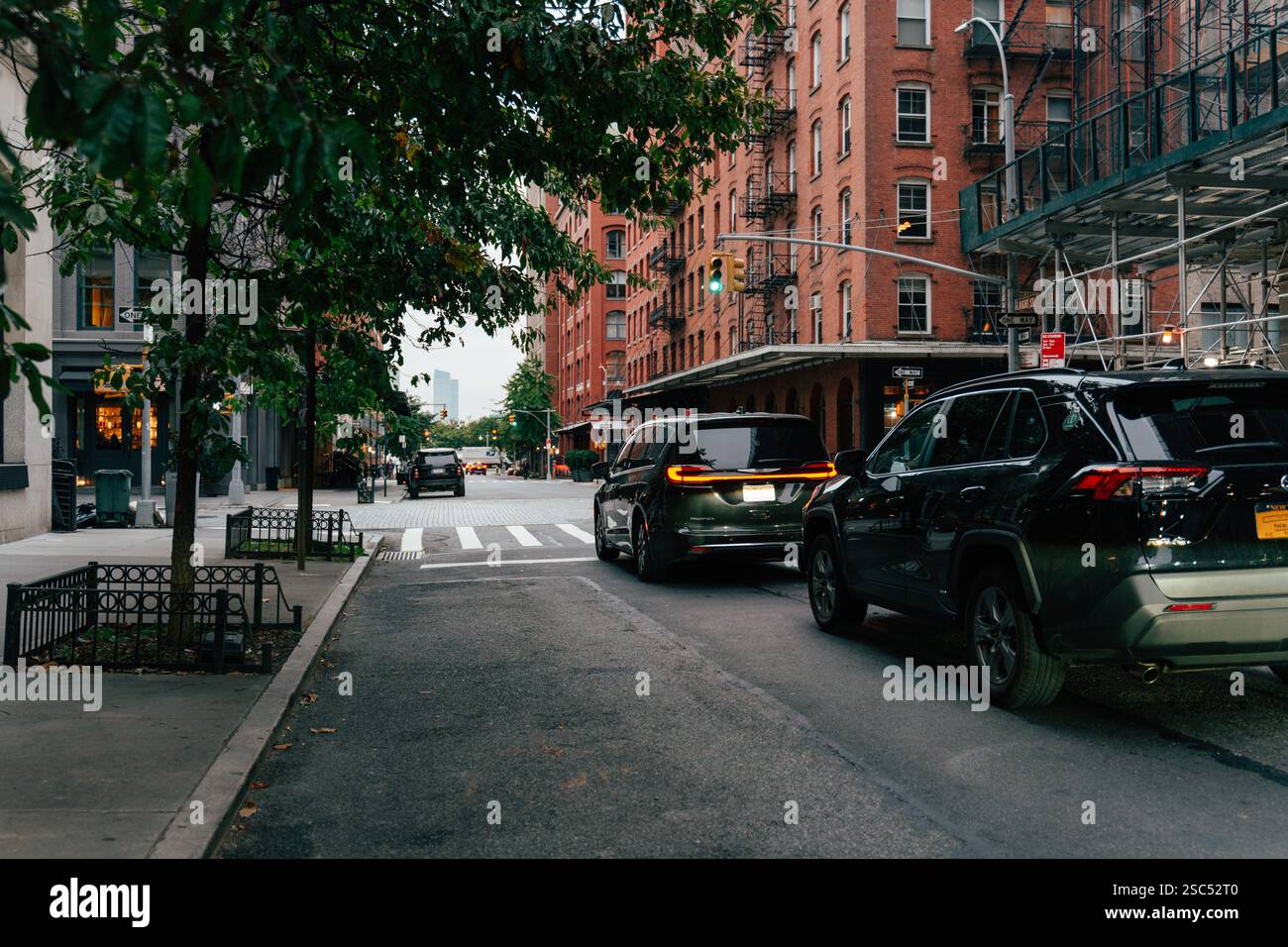Cars are navigating a bustling city street in the evening. Historic ...