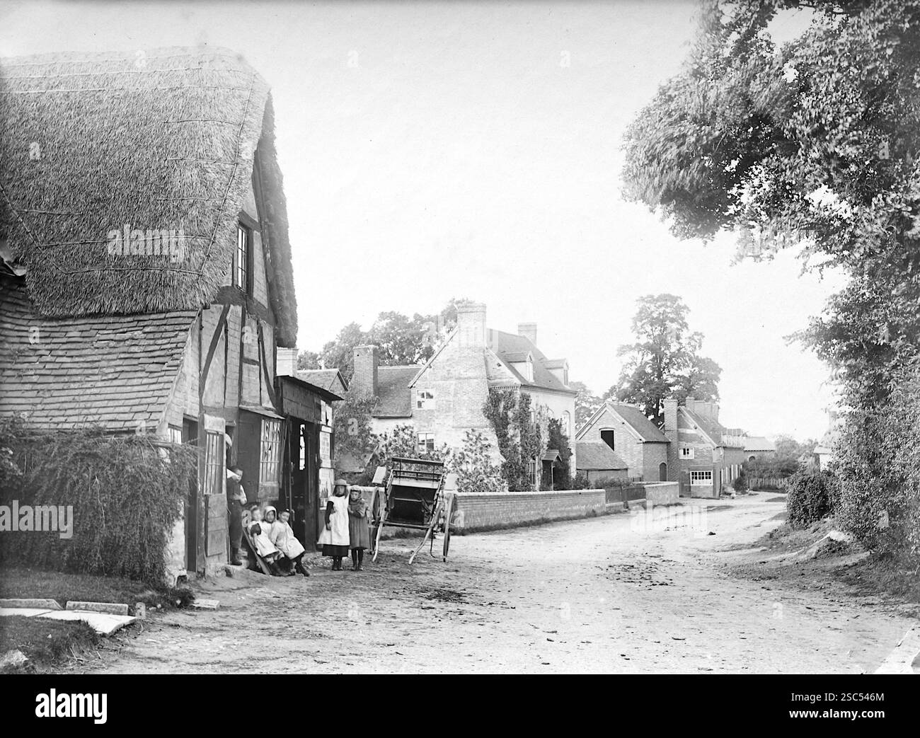 Houses, a hand cart and children playing, in the village of Aston ...