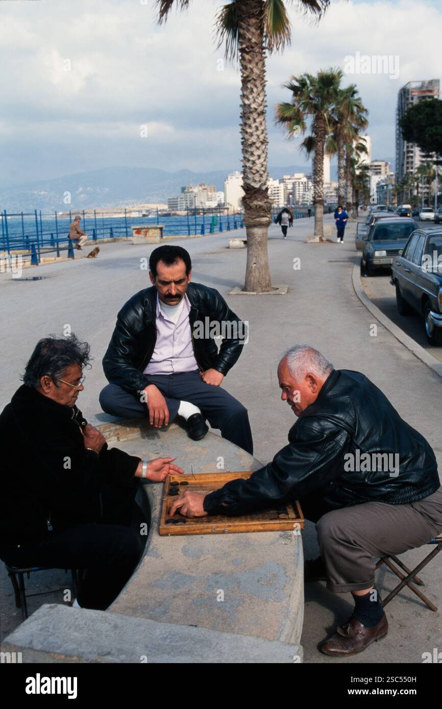 Men playing a board game on the Beirut waterfront, Lebanon, with palm ...